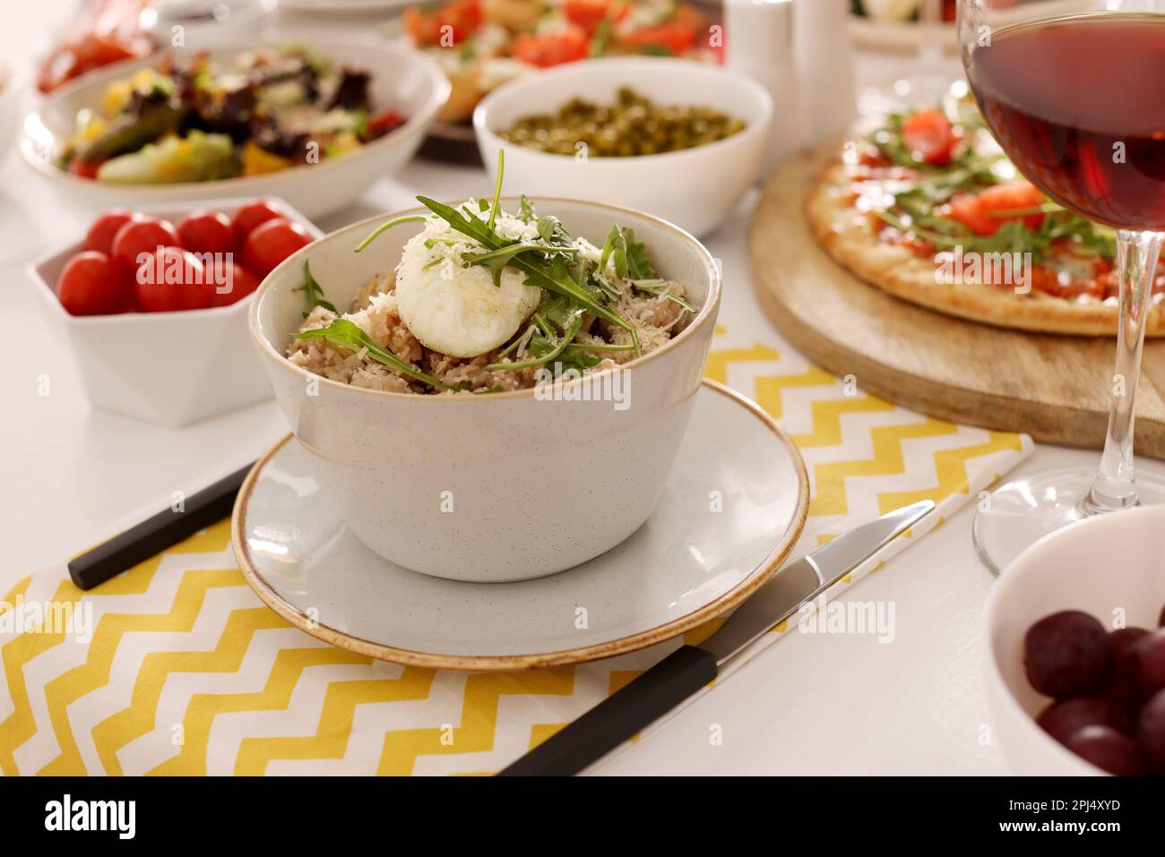 Bowl of oatmeal with poached egg, arugula and cheese served on buffet ...