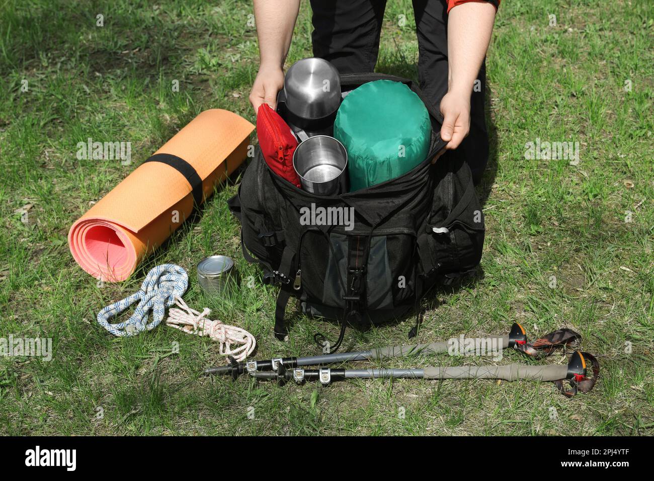 Hiker packing backpack outdoors, closeup. Mountain tourism Stock Photo ...