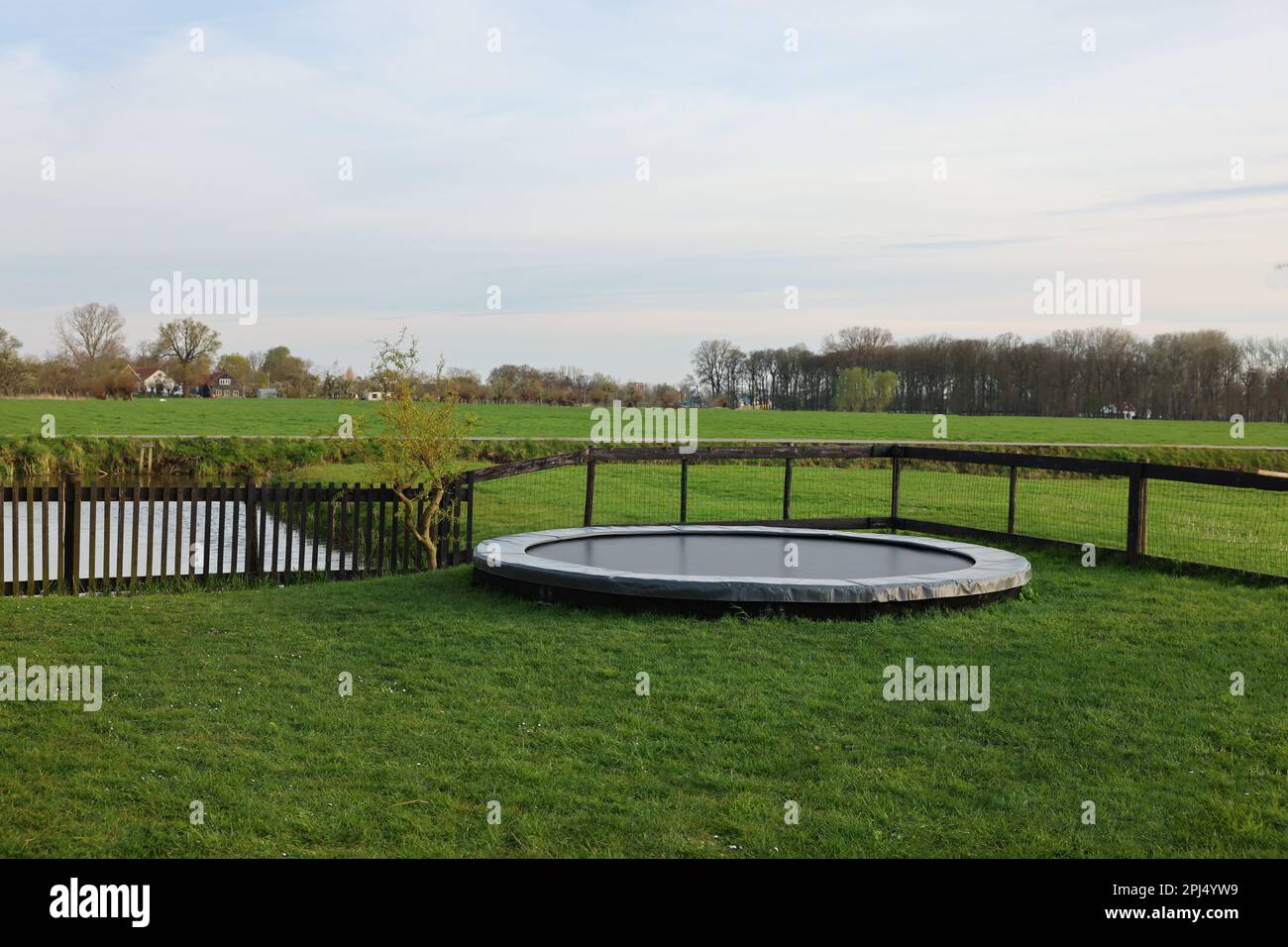 Beautiful view of green lawn with big trampoline Stock Photo - Alamy