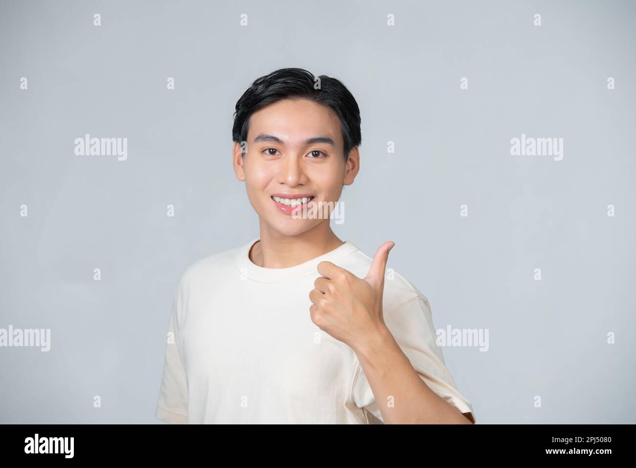 Handsome happy man smiling and thumbs up, isolated on white background ...