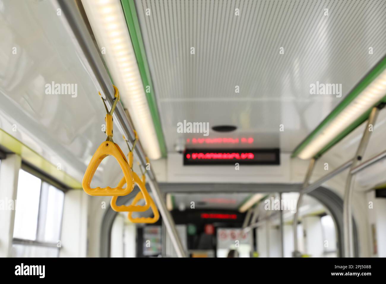 Grab pole with handgrip handles in public transport Stock Photo - Alamy