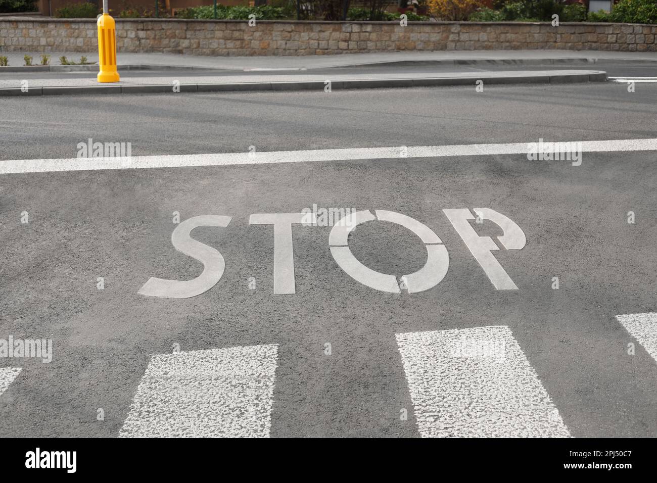 White sign STOP written on asphalt road outdoors Stock Photo - Alamy