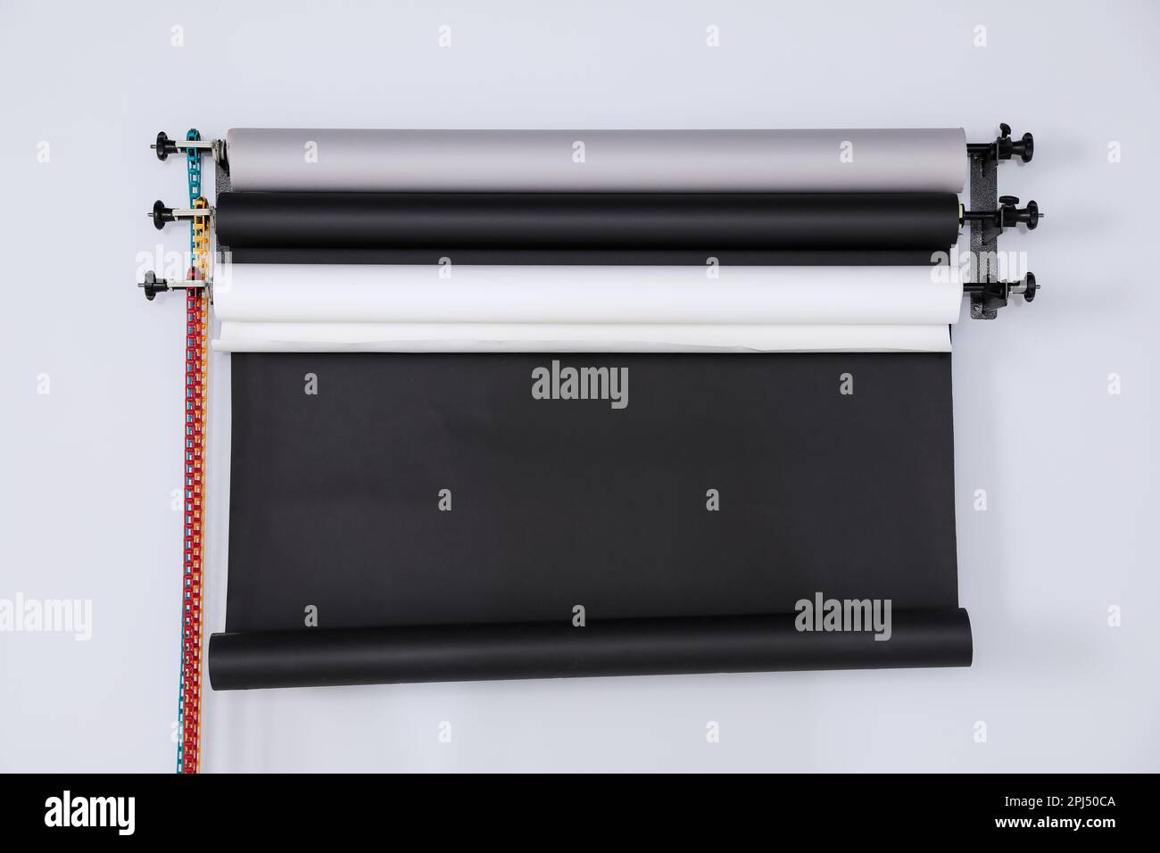 Colorful photo background rolls on white wall in studio Stock Photo - Alamy