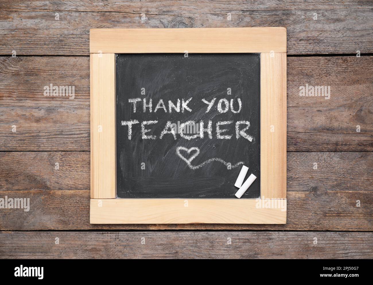 Small blackboard with pieces of chalk and phrase Thank you, teacher on ...