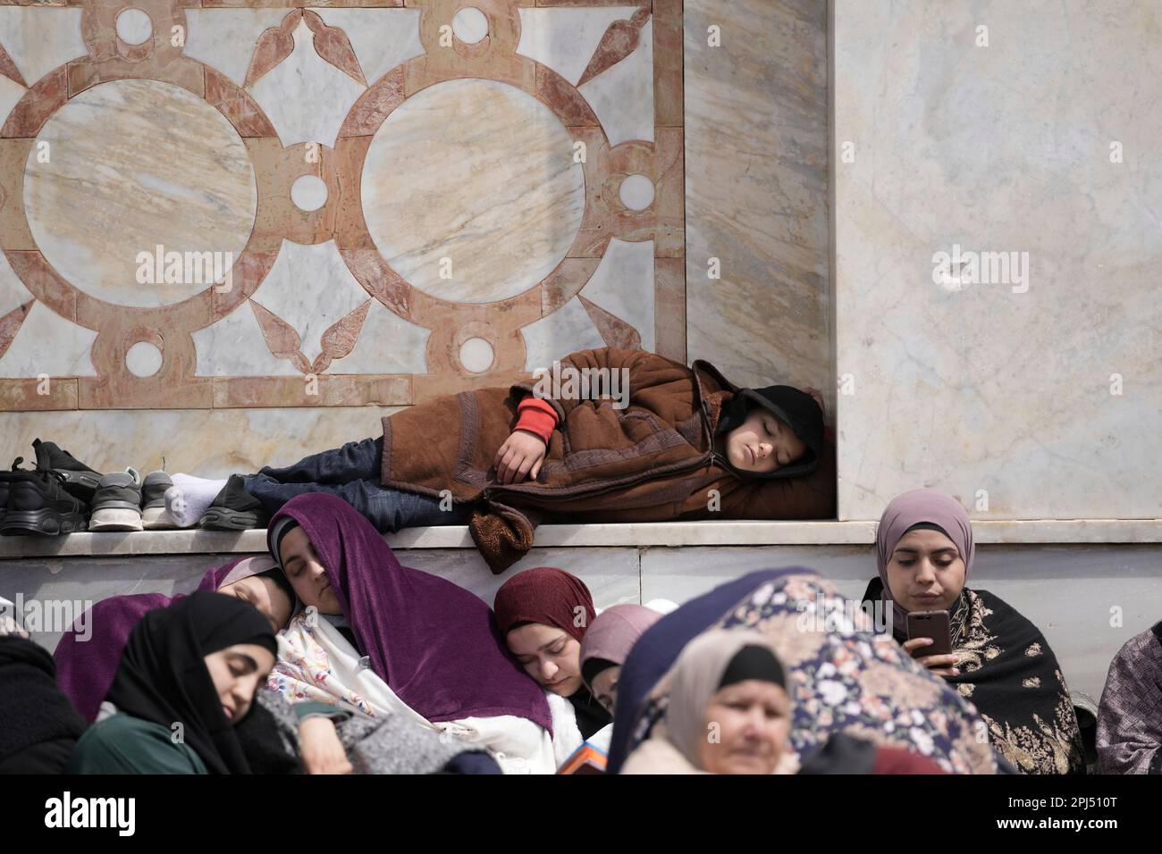 Palestinians rest before Friday prayers at the Dome of the Rock Mosque ...