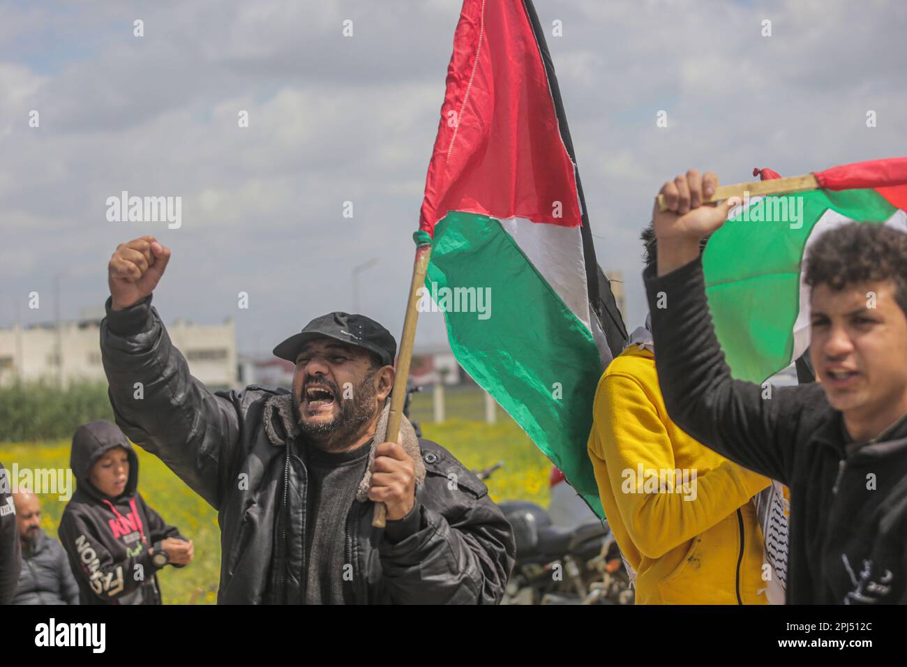 Palestinians chant slogans while holding flags during a protest marking ...