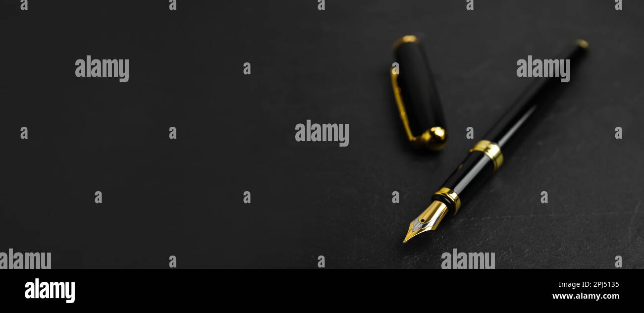 Beautiful fountain pen with ornate nib on black table, closeup view ...