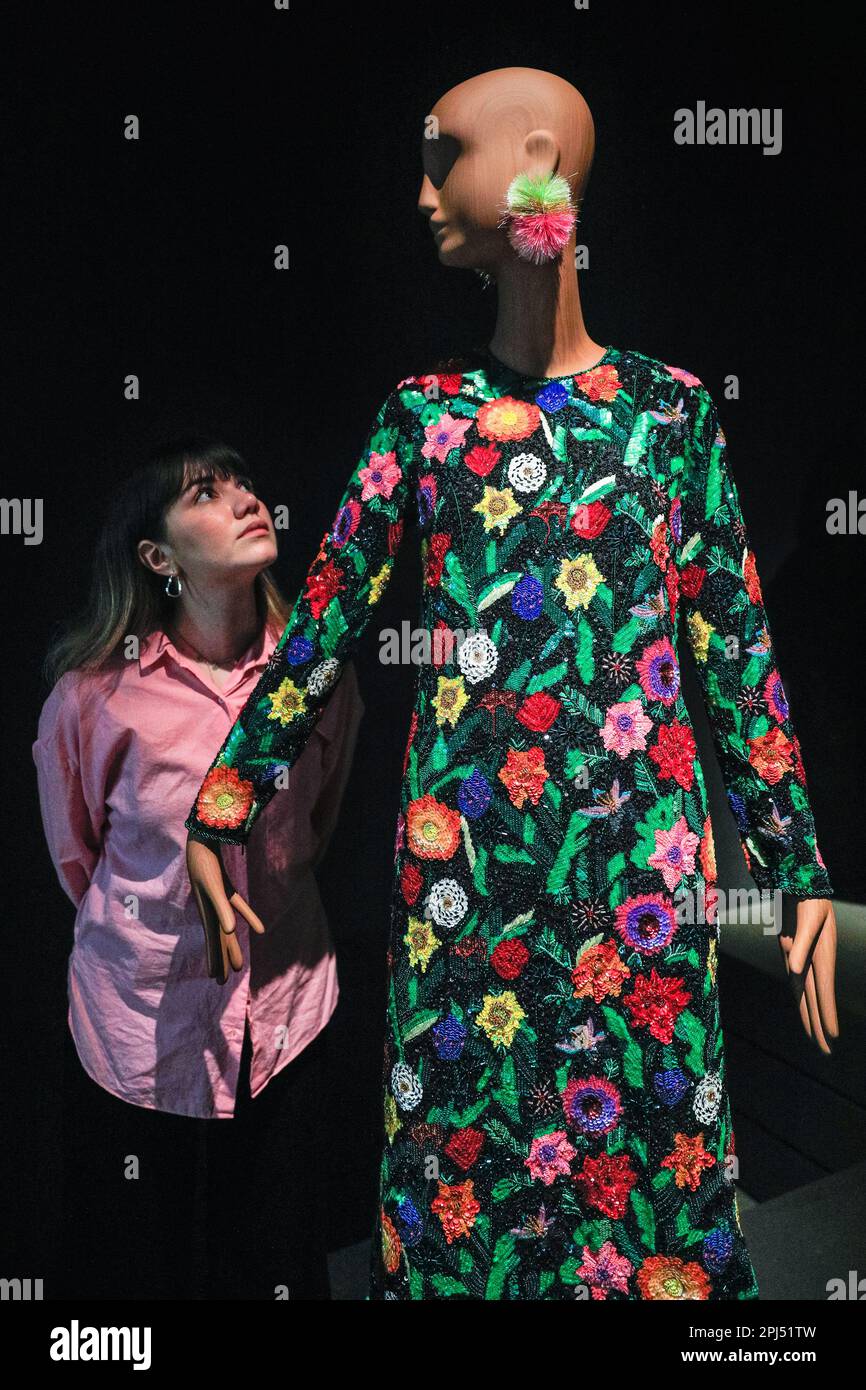 London, UK. 31st Mar, 2023. Gallery staff with "The Magic Flowers" Gown ...
