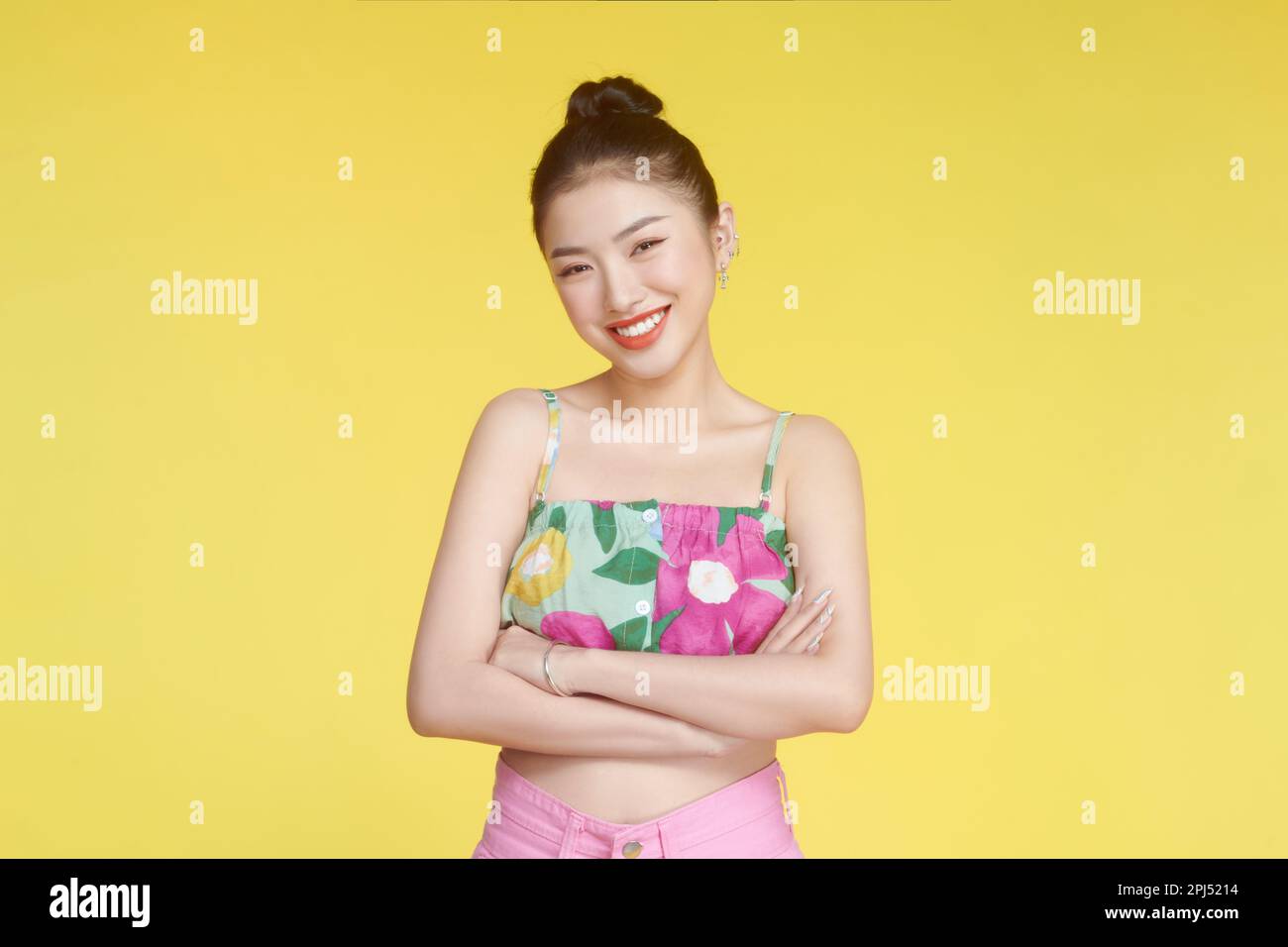 Beautiful Asian Woman Wearing Flower Tank Top Over Yellow Background