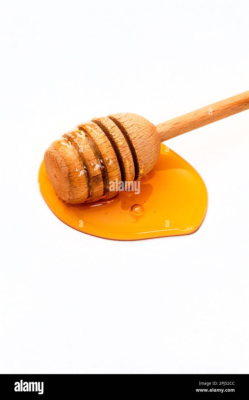 Honey with honey dipper isolated on white Stock Photo - Alamy