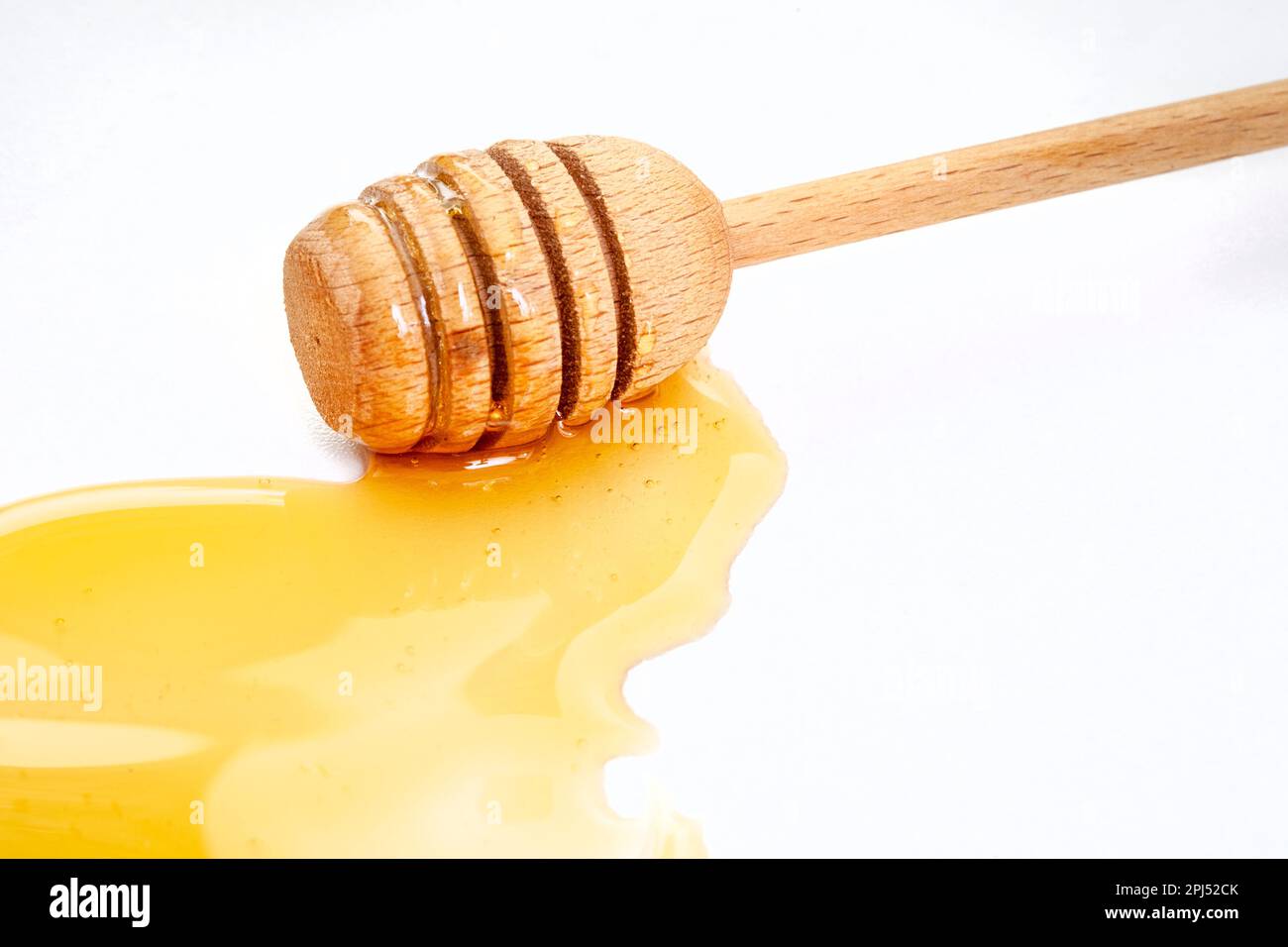 Honey with honey dipper isolated on white Stock Photo - Alamy