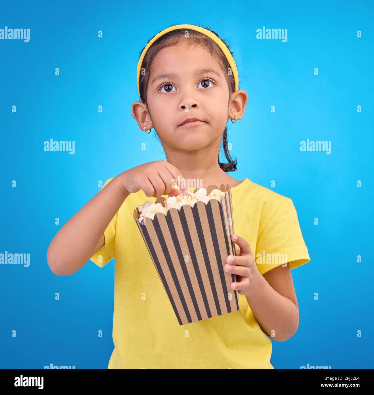 Popcorn, eating and watching movie with girl in studio for food, cinema ...