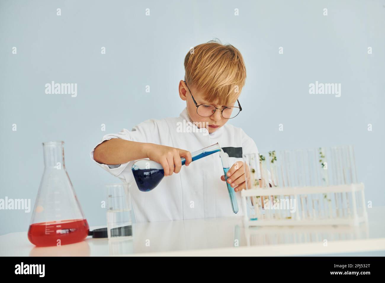 Little boy in coat playing a scientist in lab by using equipment Stock ...