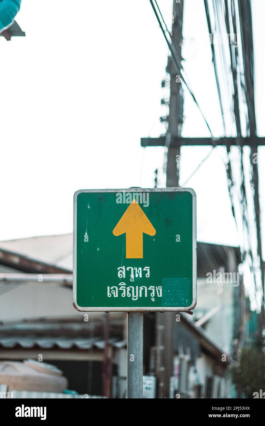 A vertical image of a green sign located in Thailand, a country in ...