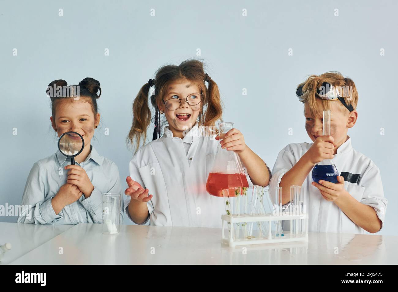 Happy friends smiling. Children in white coats plays a scientists in ...