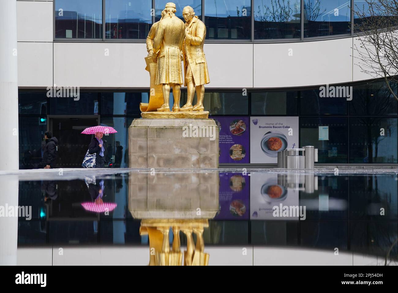 A woman walks by the 'golden boys' statue, featuring Matthew Boulton ...