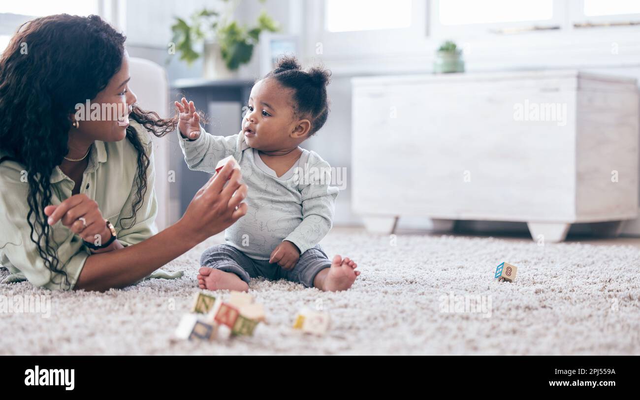 Black baby, mother and toy letter blocks for language development on ...