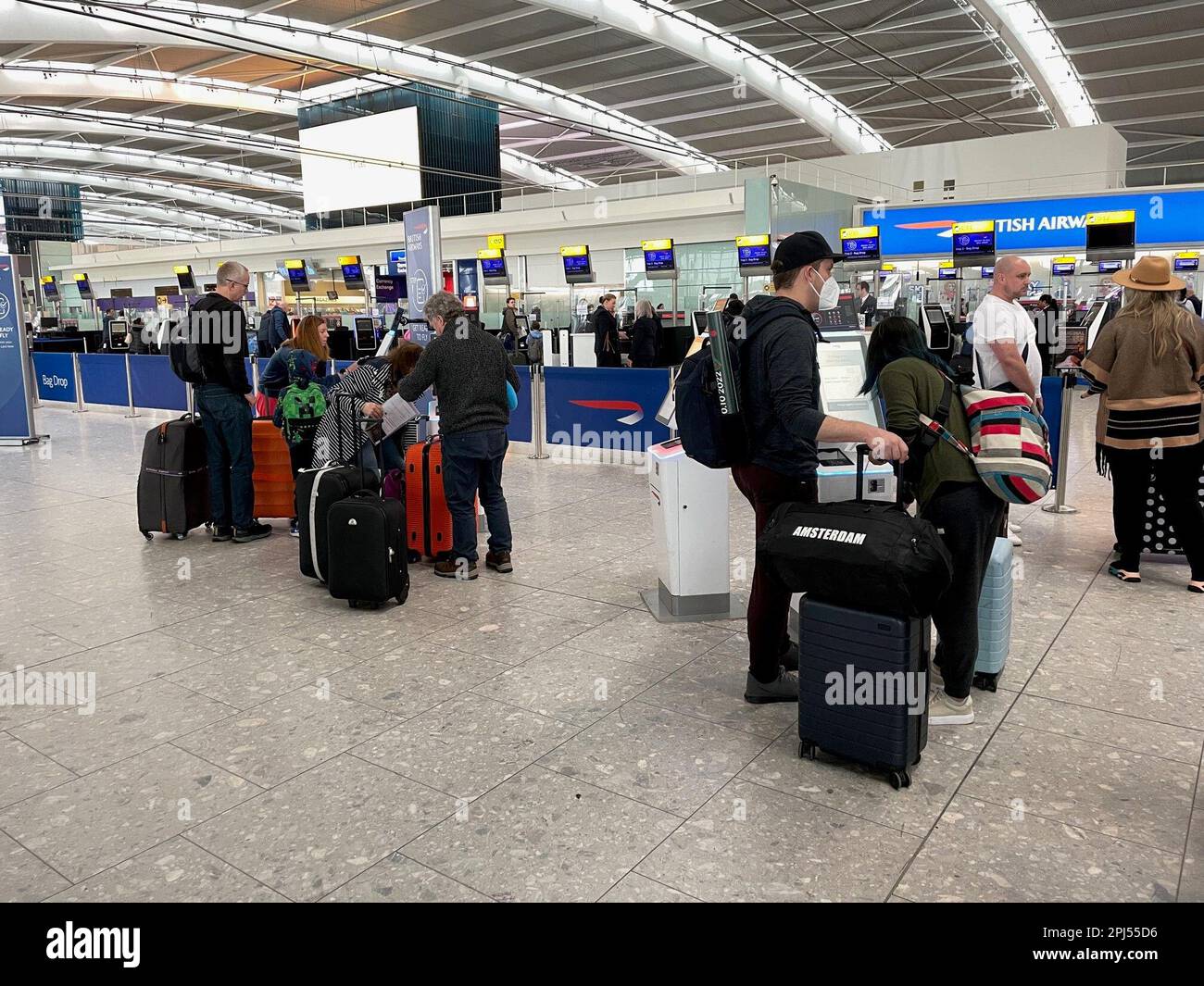 Passengers wait in line to check in at Terminal 5 of Heathrow Airport ...