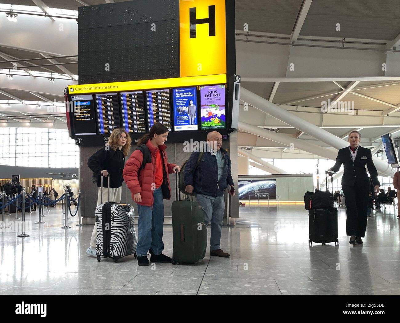 Passengers in Terminal 5 at Heathrow Airport, London, as security guard ...
