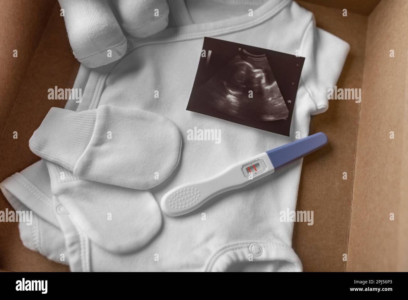 Box with baby stuff and pregnancy test Stock Photo - Alamy