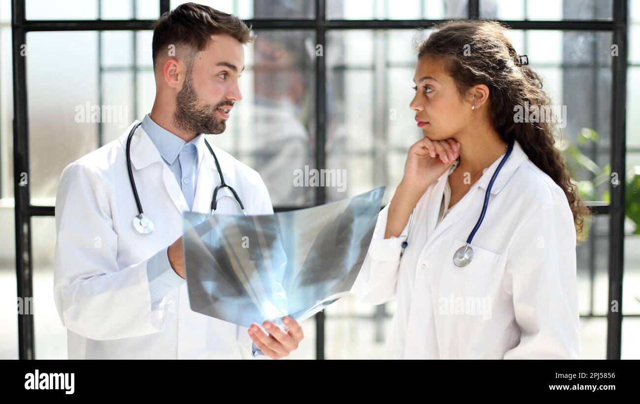 Two busy doctors working with papers and xray images Stock Photo - Alamy