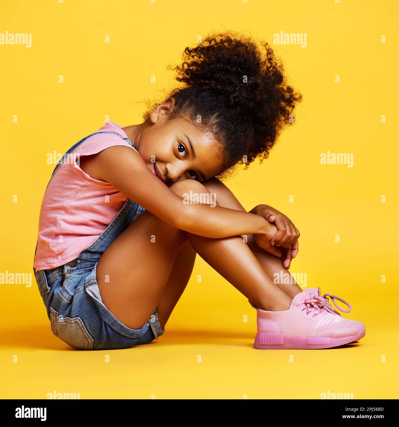 Portrait, shy and girl child on studio floor for children fashion ...