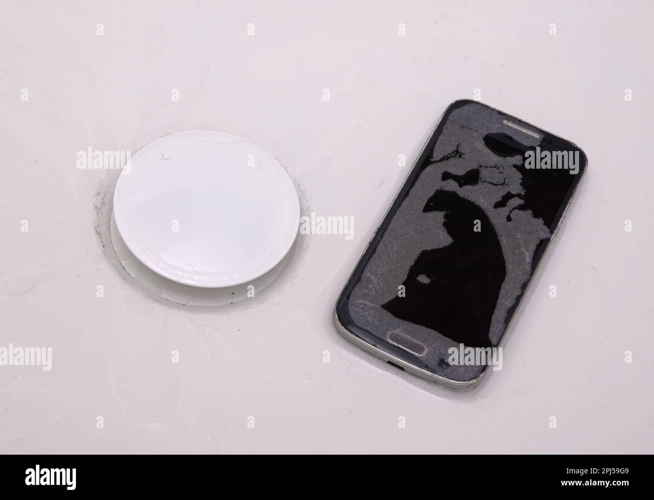 Black smartphone is lying in the water - Fallen in the bathtub Stock ...