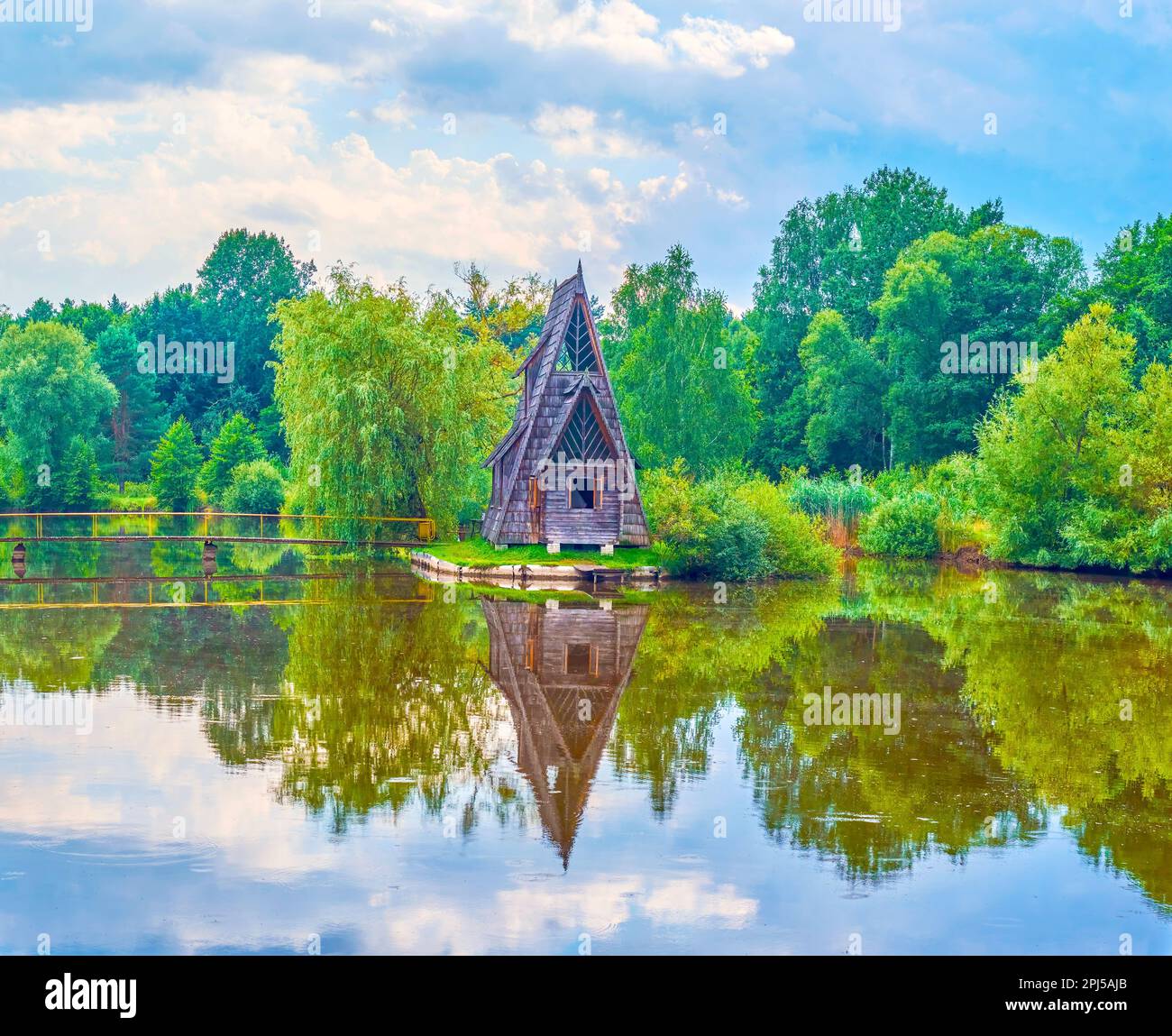 The mirror-like surface of the lake reflects the forest and the small ...