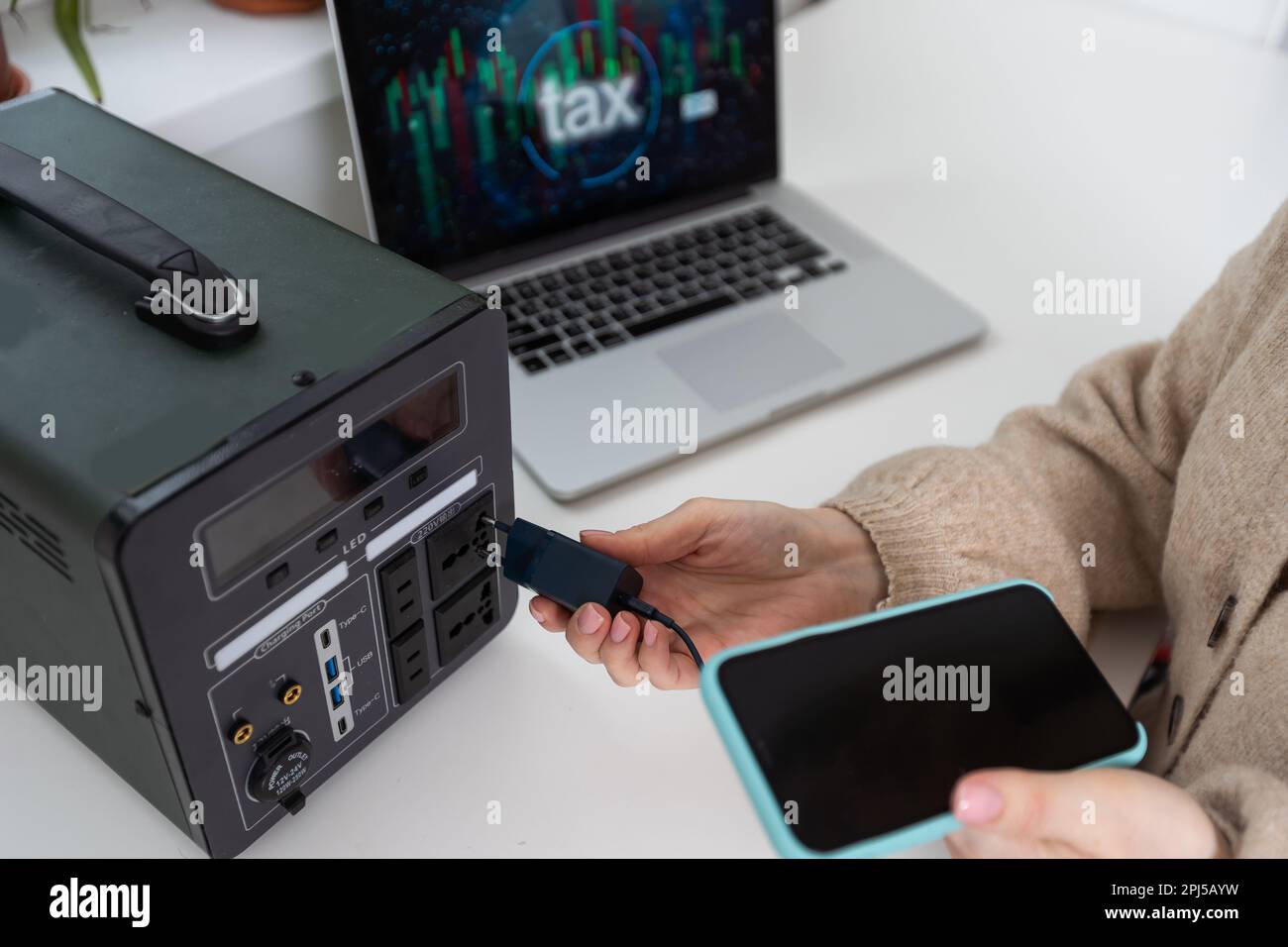 Portable power station charging gadgets in living room Stock Photo - Alamy