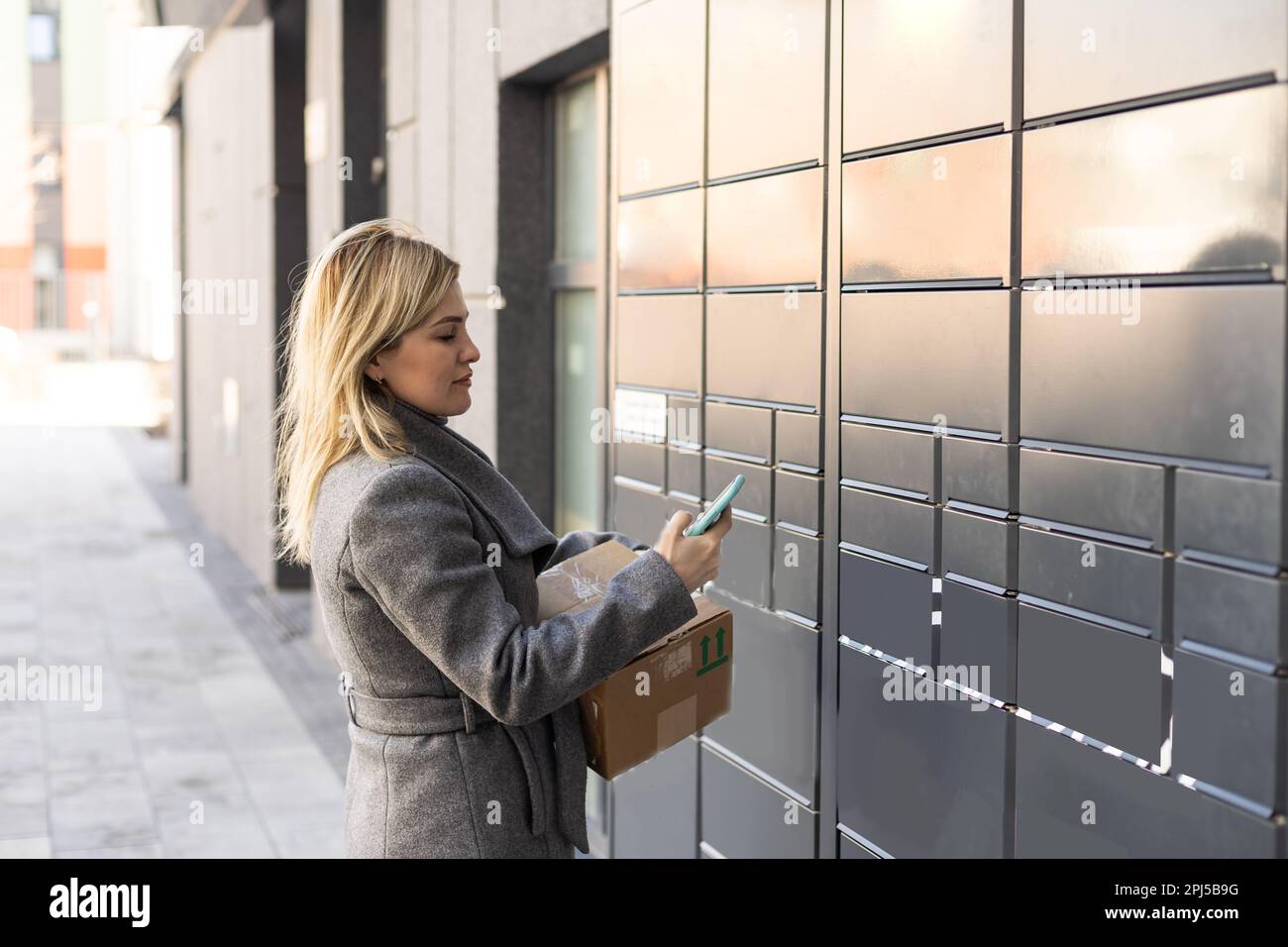Beautiful woman picking up a package from a smart electronic steel ...