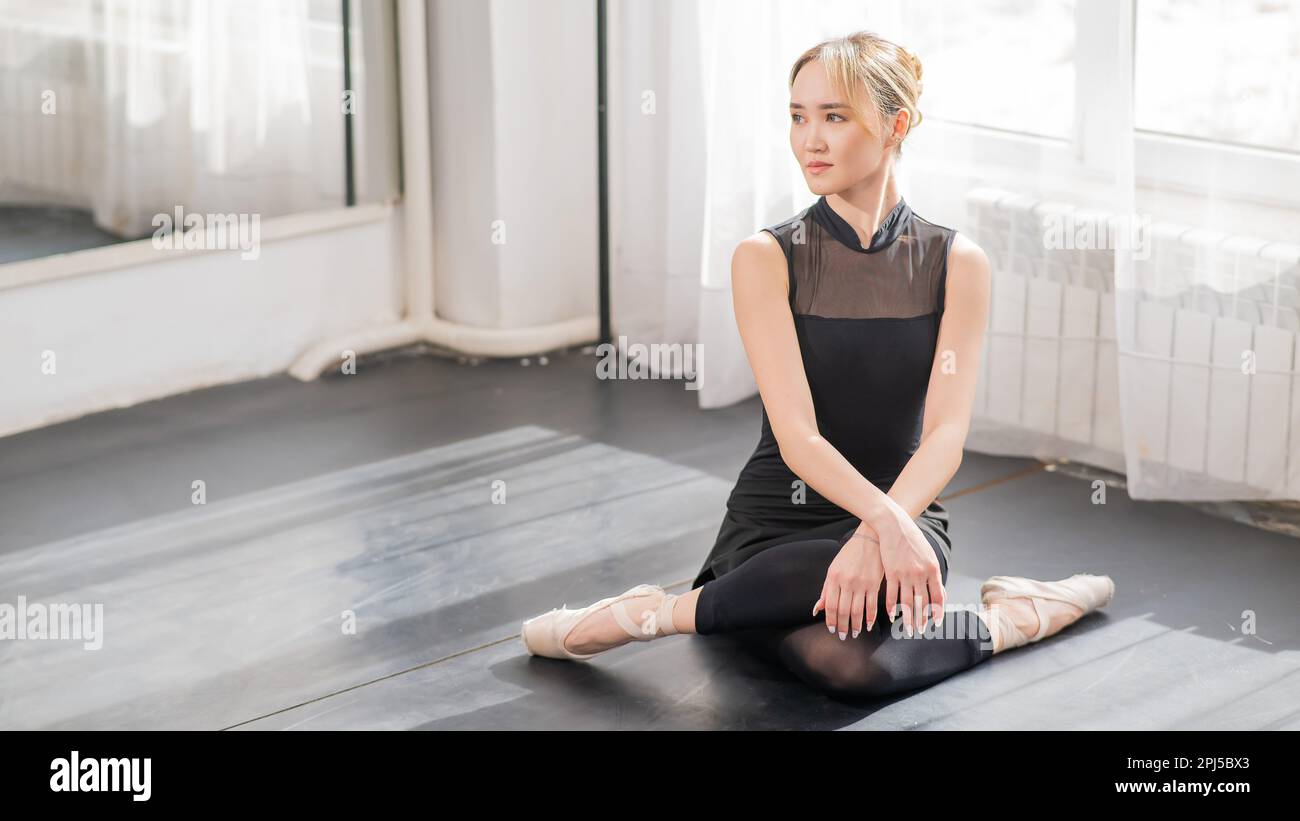 Beautiful Asian ballerina sitting on the floor cross-legged Stock Photo ...