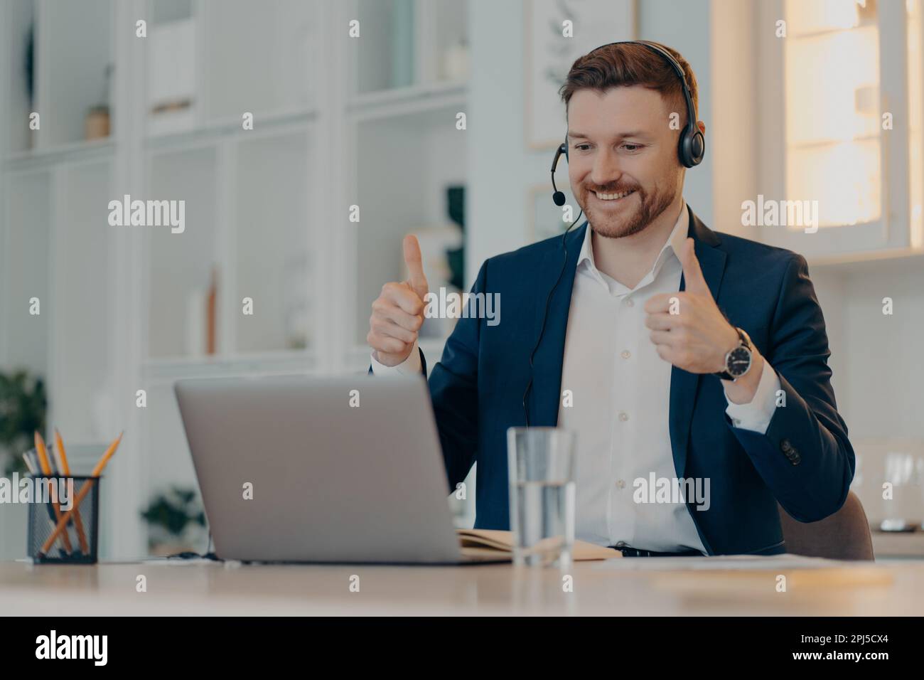 Happy male employee makes okay like gesture keeps thumbs up satisfied ...