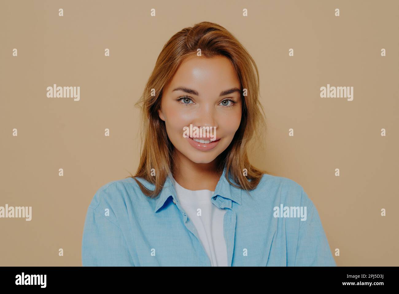 Headshot portrait of happy brunette model female in blue shirt smiling ...