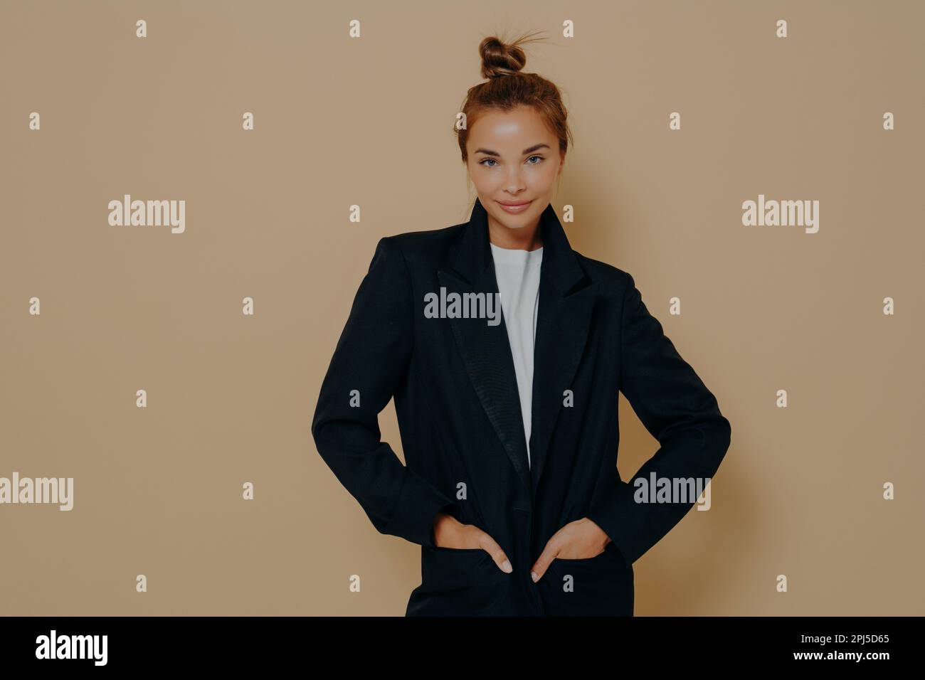 Attractive young model female in black suit with hair tied up in high ...