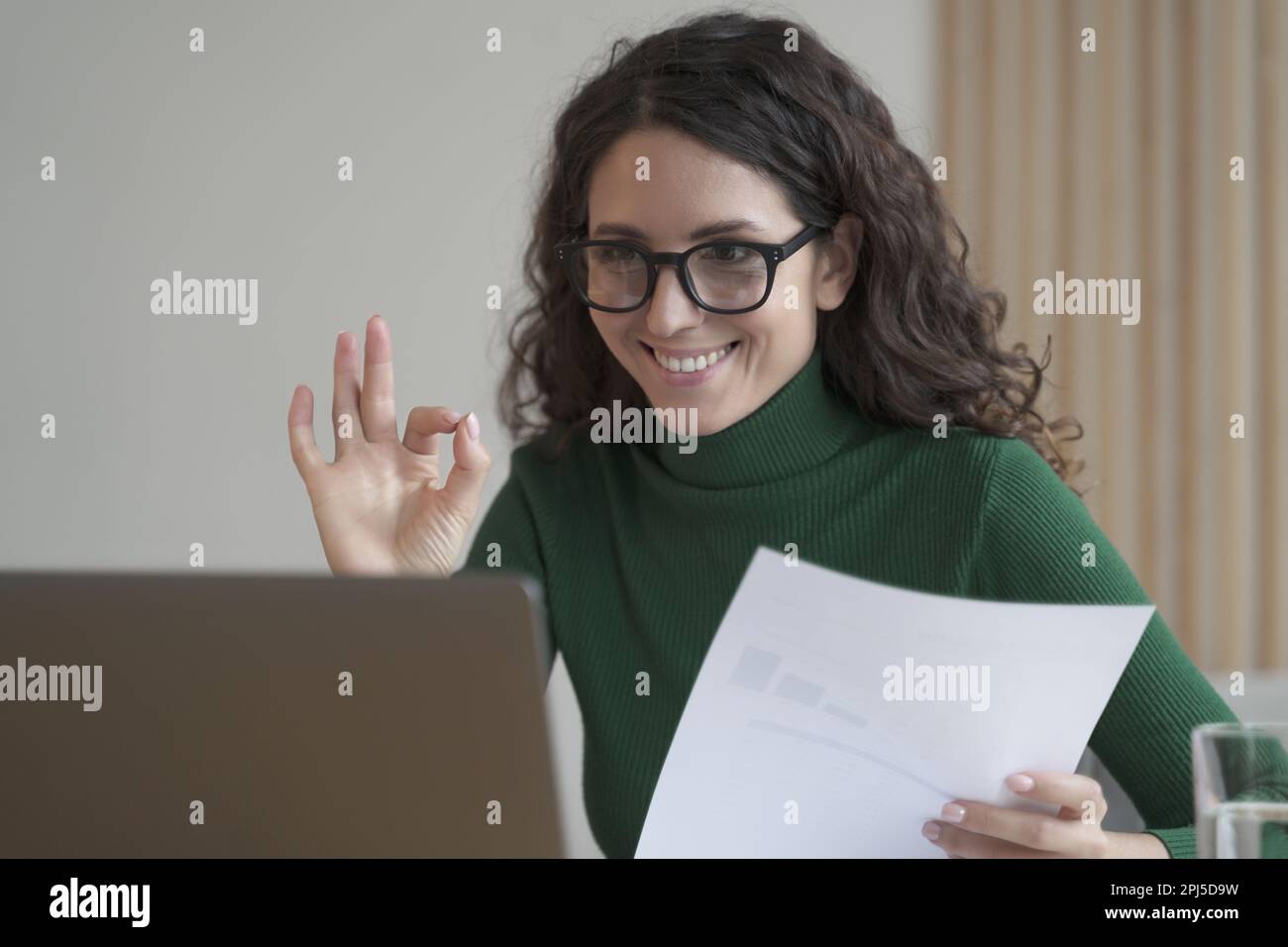 Smiling Italian female employee holding financial report and showing ...