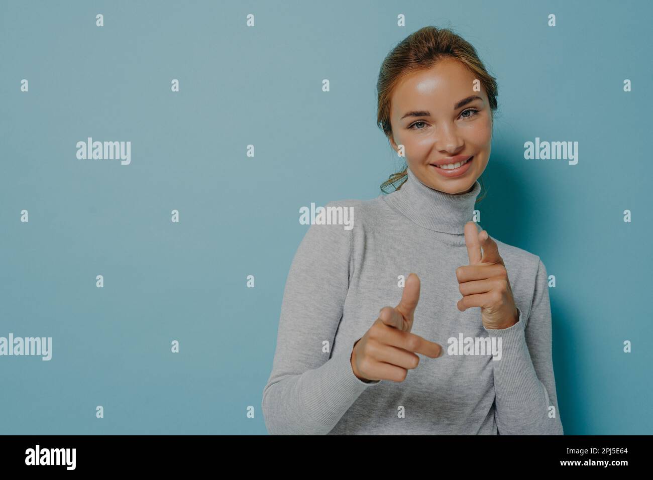 I choose you. Attractive young lady in knitted turtleneck points with ...