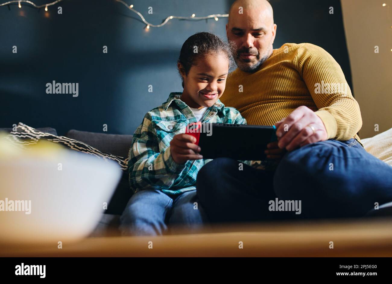Father supporting son with Down syndrome playing computer game Stock ...