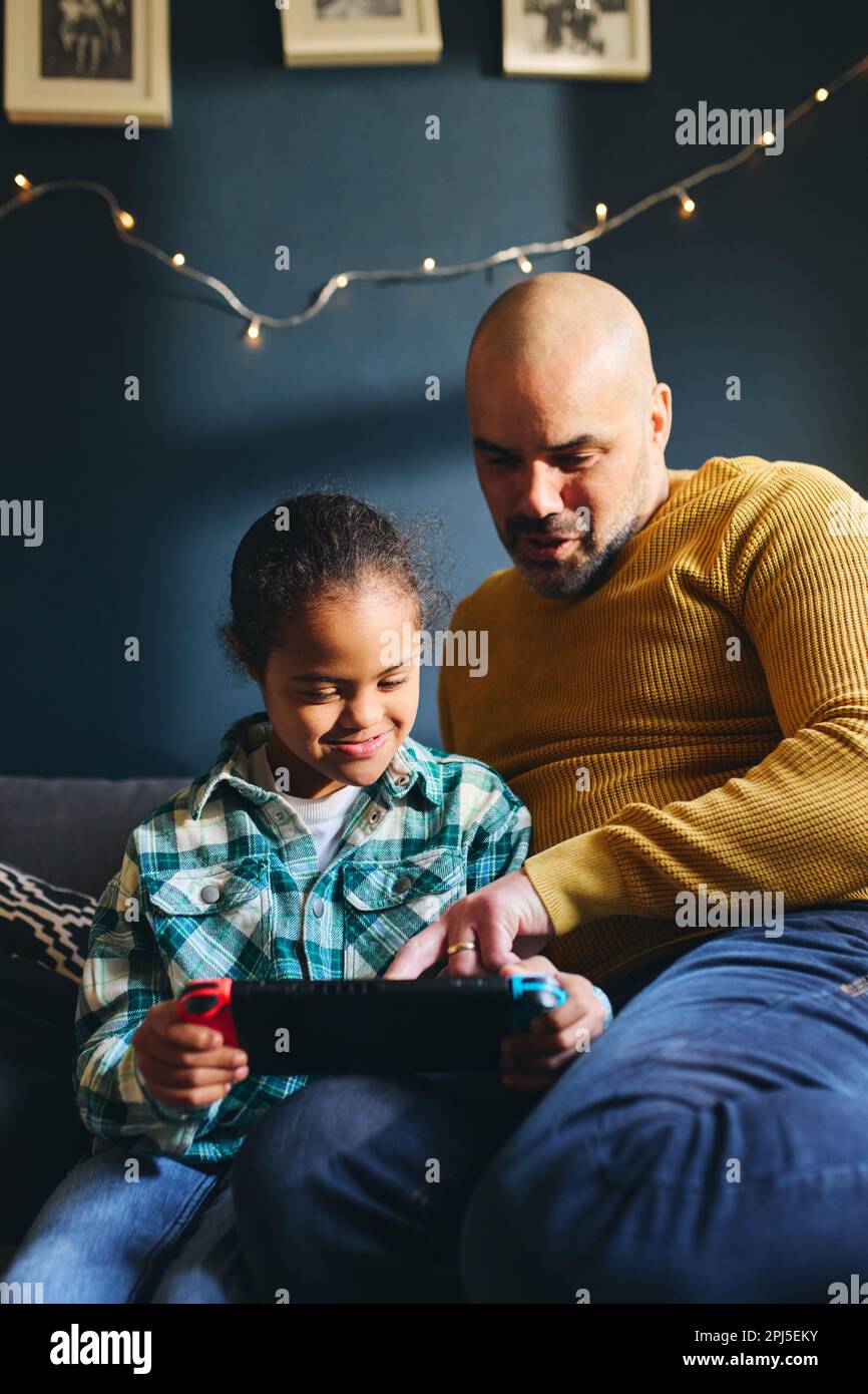 Boy with Down syndrome playing computer game, father helping Stock ...