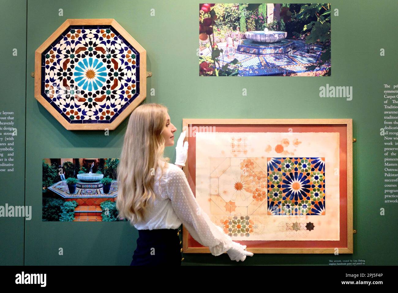 Exhibition curator Rosie Alderton adjusts artwork by Lisa Delong, 2023 ...