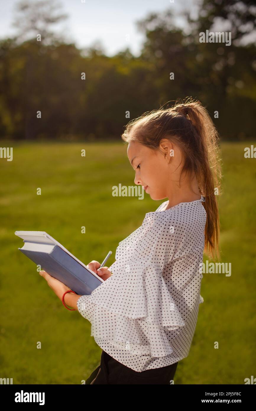 child girl holding notebooks outdoor. Back to school concept Stock ...