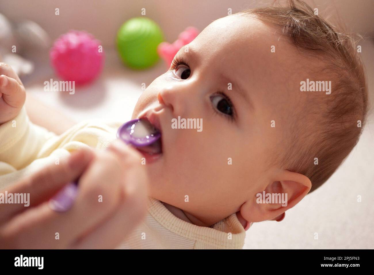 Newborn child drinking water or medicine cough syrup with spoon, close ...