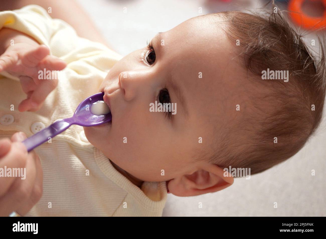 Newborn child drinking water or medicine cough syrup with spoon, close ...