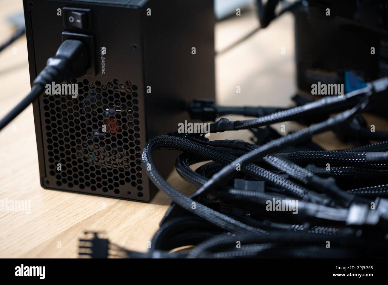 Tangled black computer cables lying on a brown wooden table Stock Photo ...
