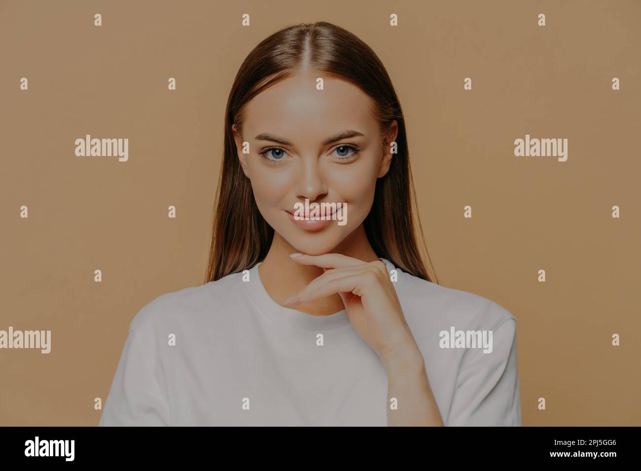 Lovely young European woman with makeup healthy skin touches gently ...