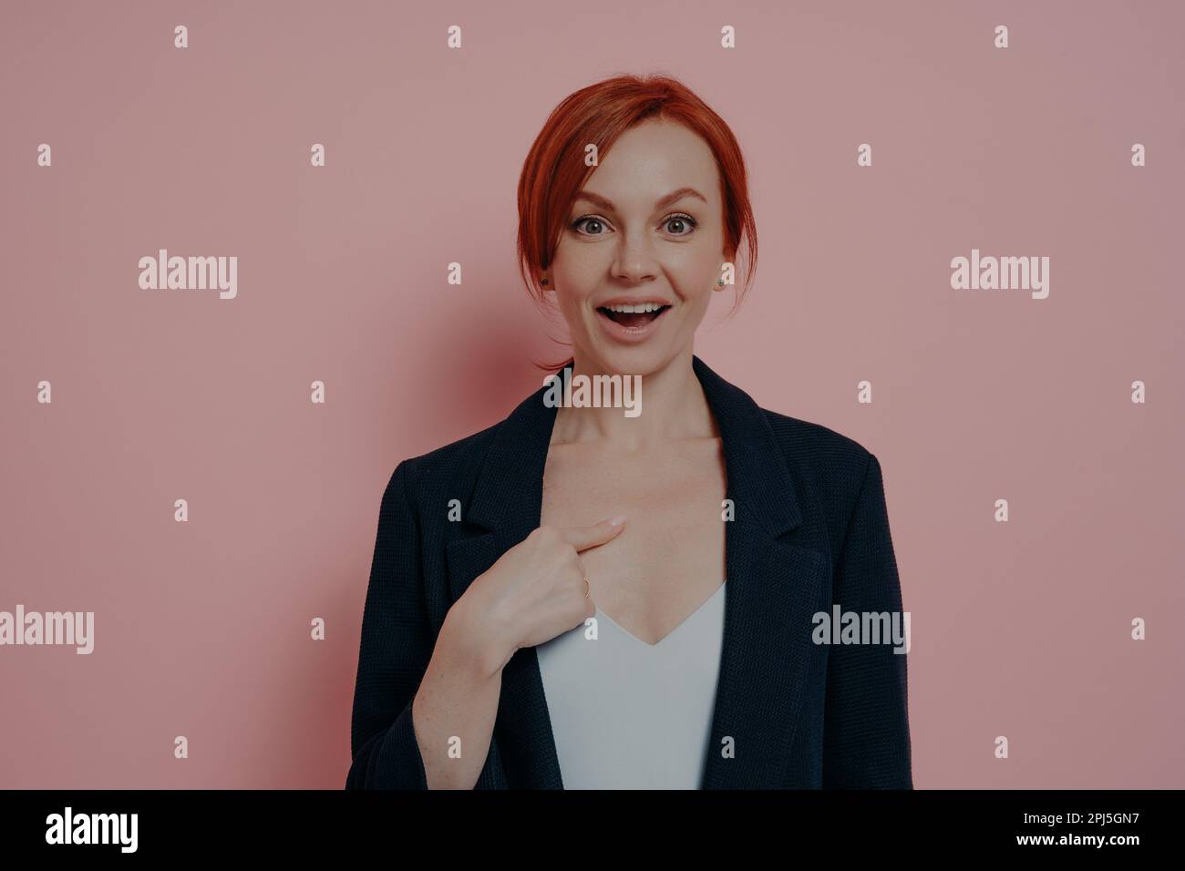 Portrait of happy smiling young red-haired woman asking question you ...