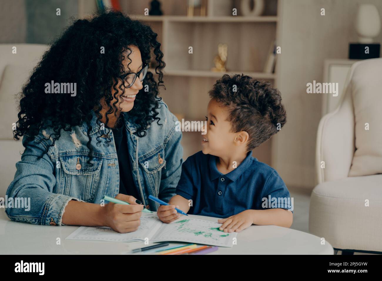 Beautiful afro american family of two, mother and son looking at each ...