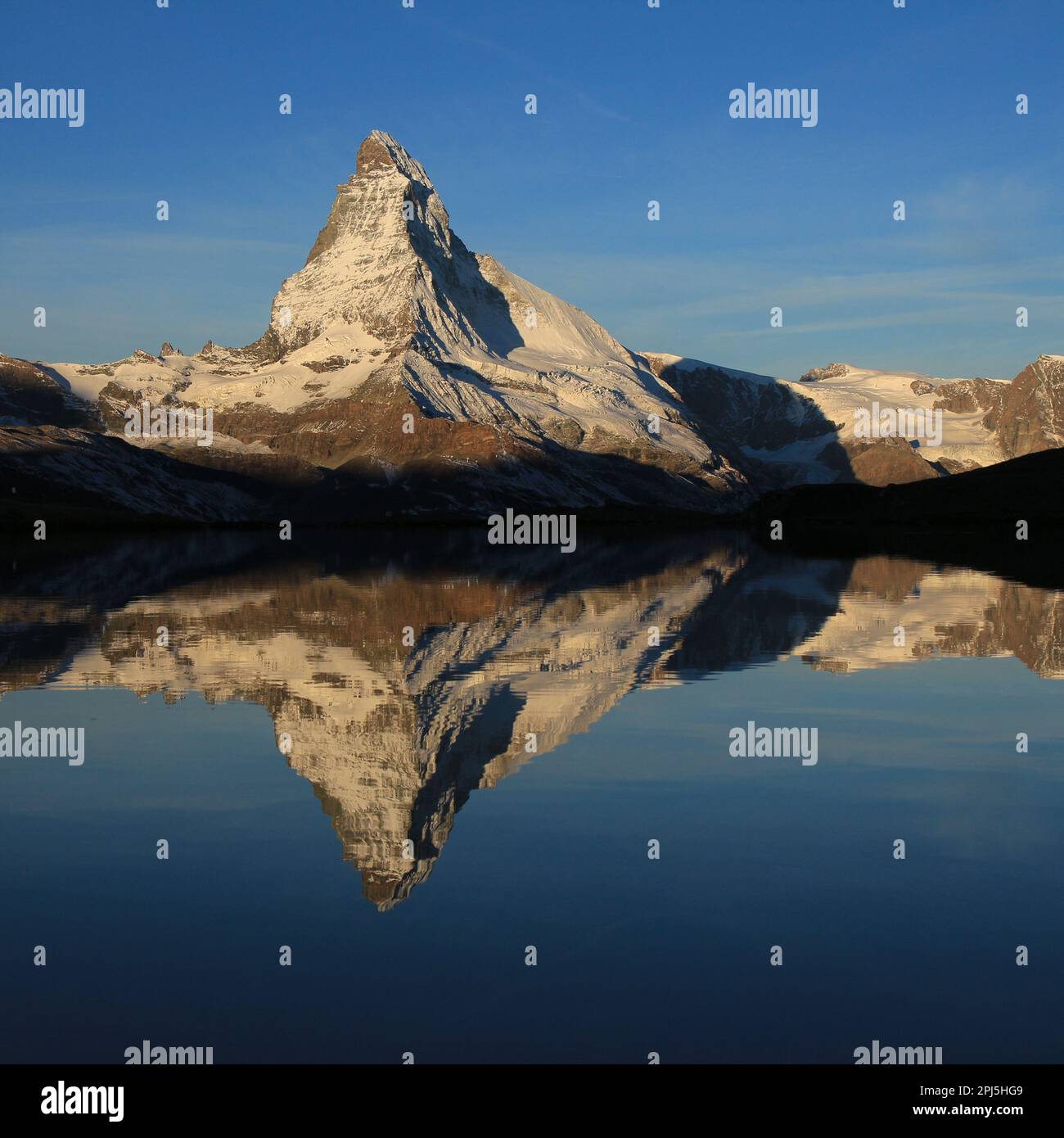 Snow capped Mount Matterhorn reflecting in Lake Stellisee Stock Photo ...