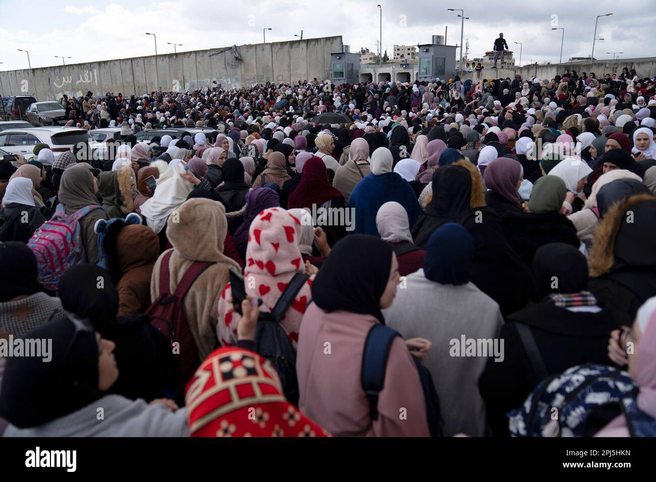 Palestinian women gather in front of the designated security checkpoint ...
