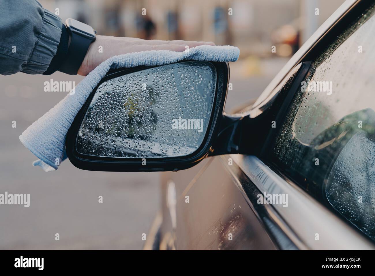 Professional car wash. Hand of man washing car side rear view mirror ...