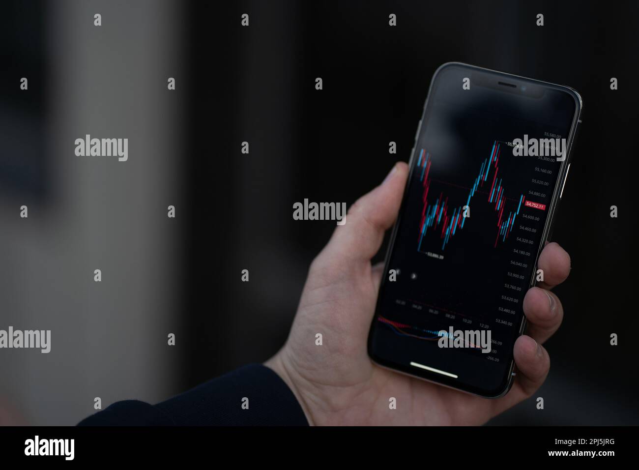 Mobile app for trading online. Male hand holding smartphone with ...